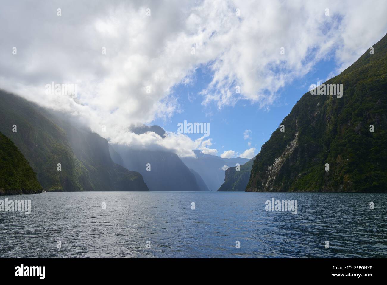 Wide fjord with steep, forested slopes and dramatic cloud formations in ...