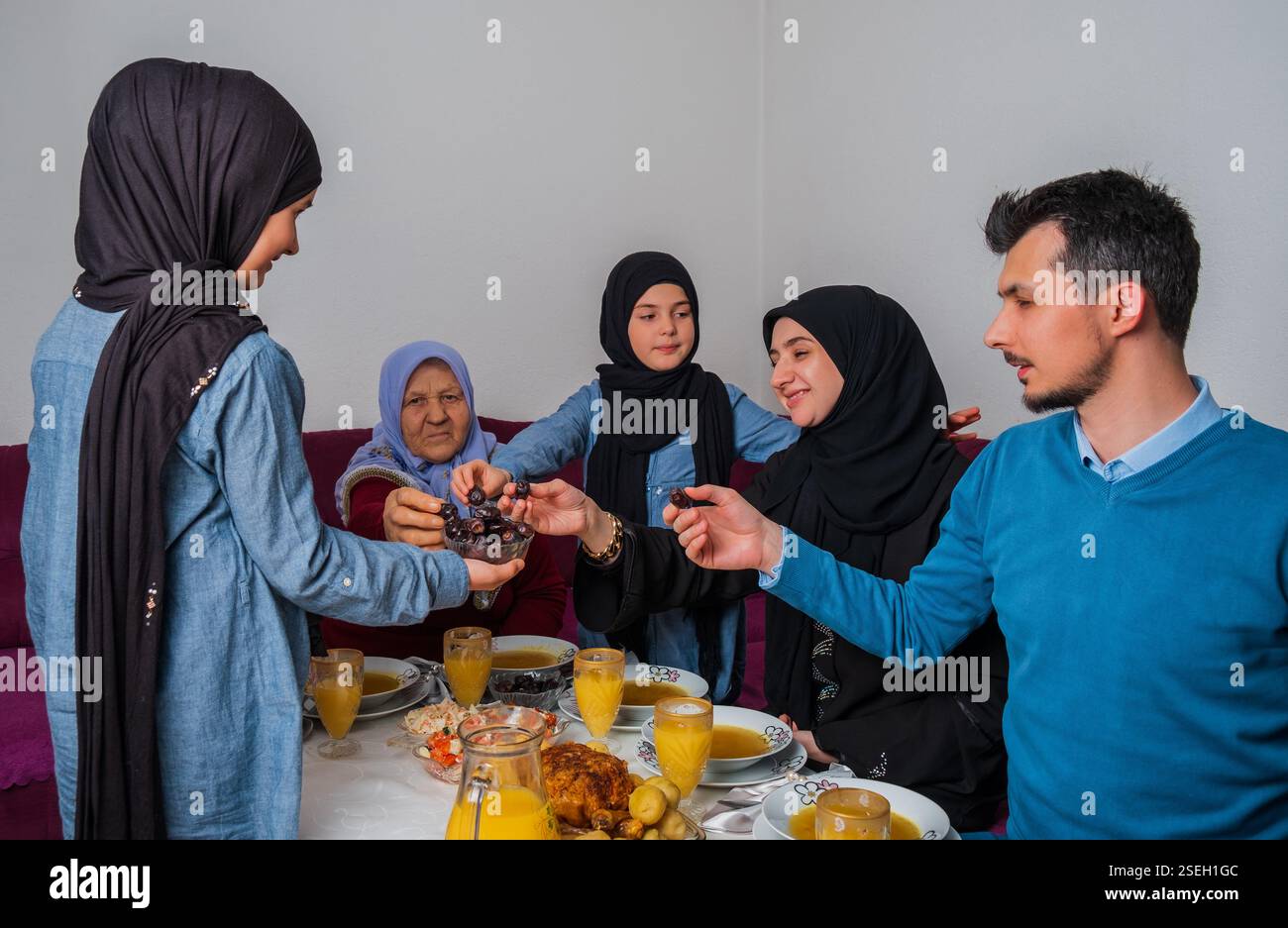 Happy Muslim family having iftar dinner at home during Ramadan dining ...