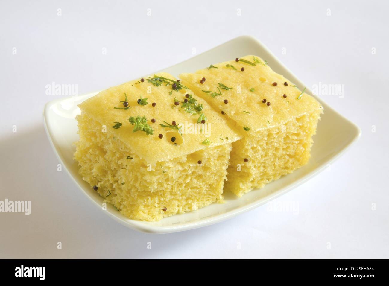 Indian cuisine, fast food Dhokla served in dish on white background ...