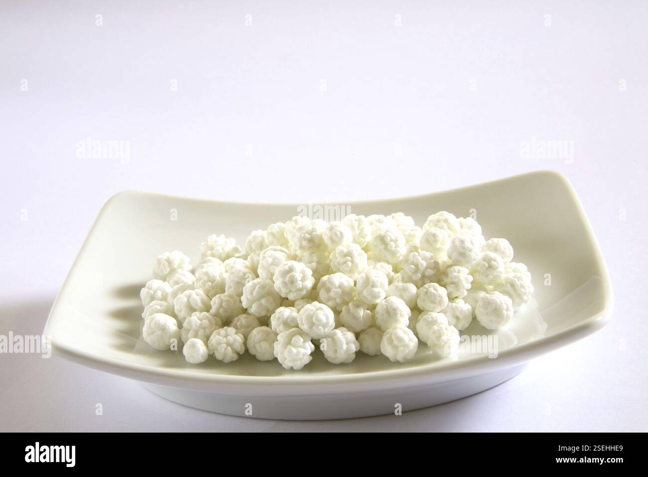 Sweet small sugar ball phutana in plate on white background Stock Photo ...