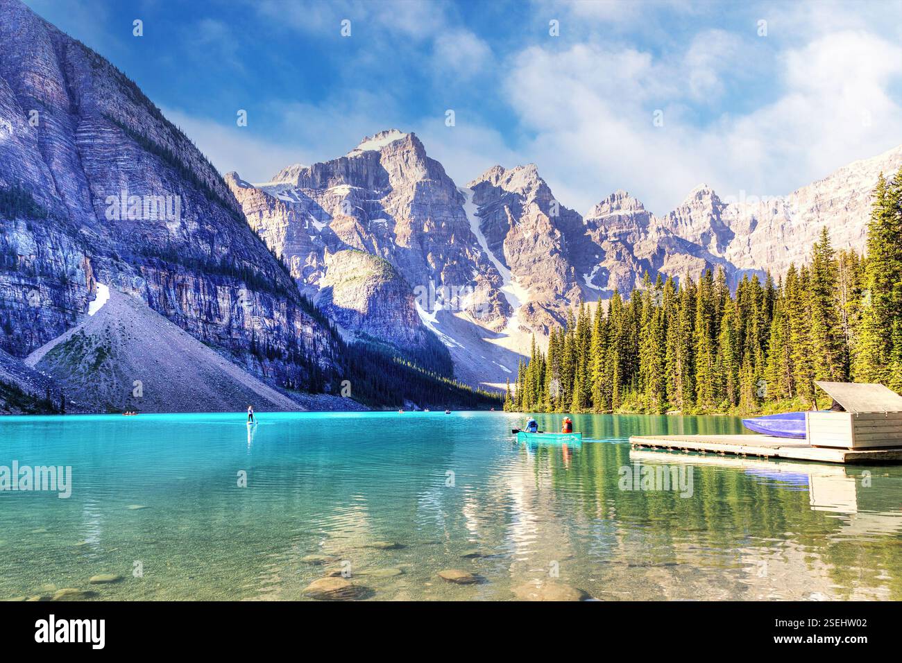Visitors canoeing their boats on turquoise-colored Moraine Lake in the Canadian Rockies of Banff ...