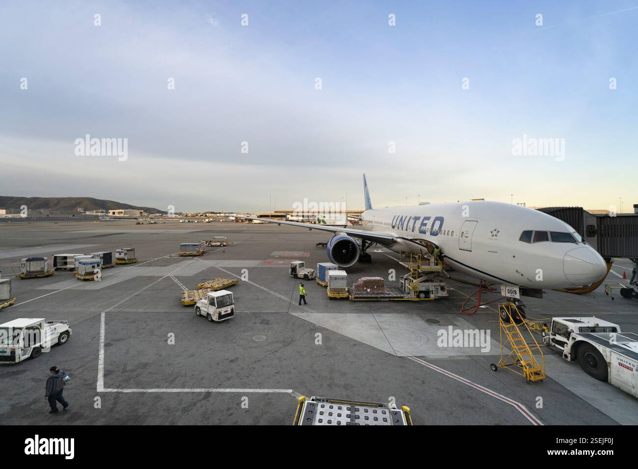 United Airlines plane (likely a Boeing 777) being loaded/unloaded ...