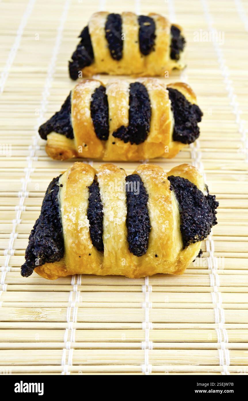 Three pieces of puff pastry filled with poppy seeds, sprinkled with ...