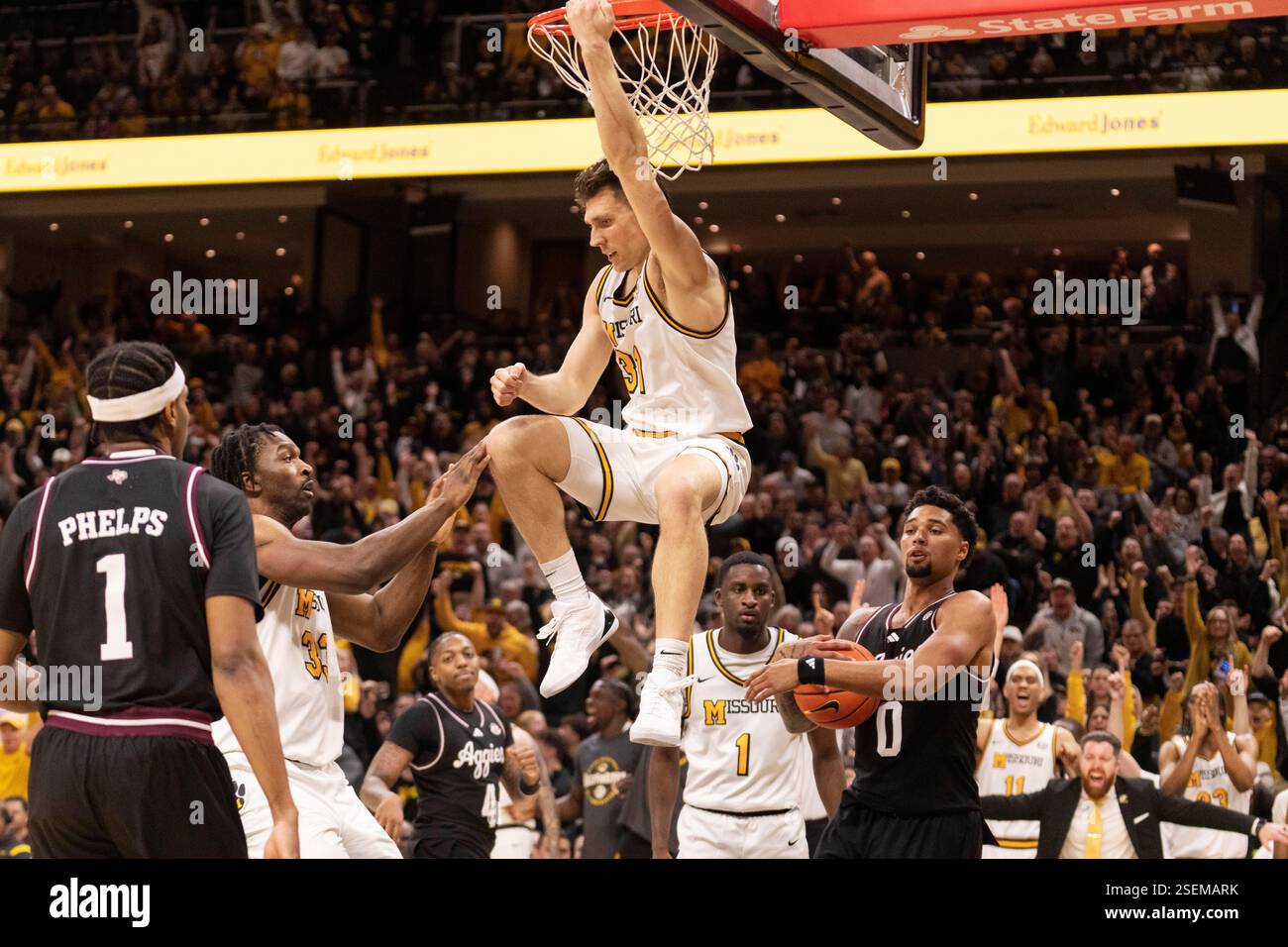 Missouri's Caleb Grill hangs from the rim after dunking the ball during ...