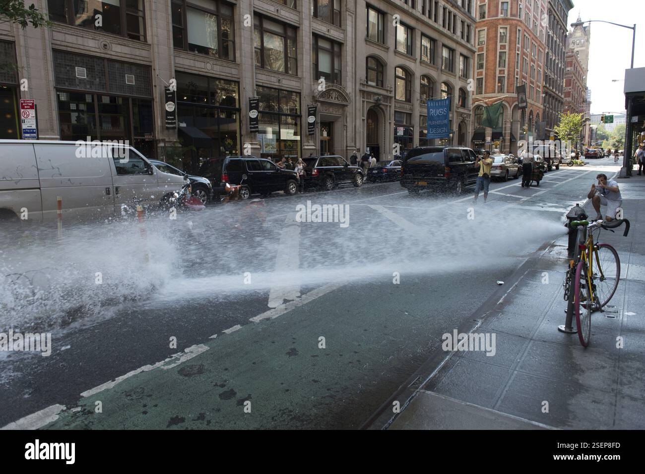 Spray of water from broken johnny pump on Manhattan, New York, USA ...