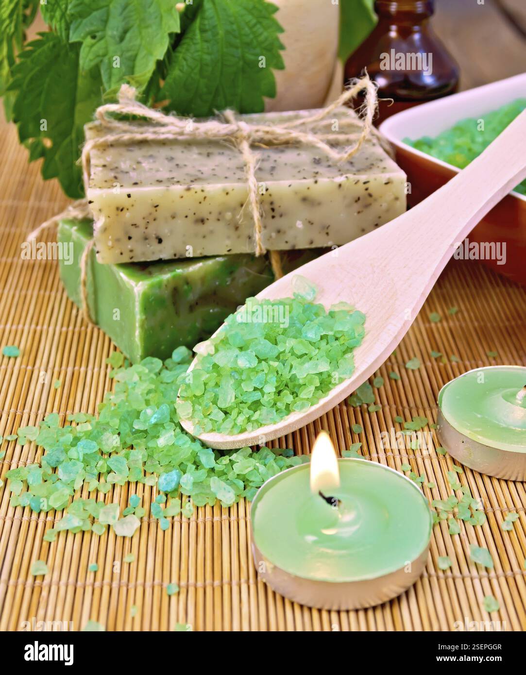 Bath salt in spoon, two bars of homemade soap with twine, oil bottle ...