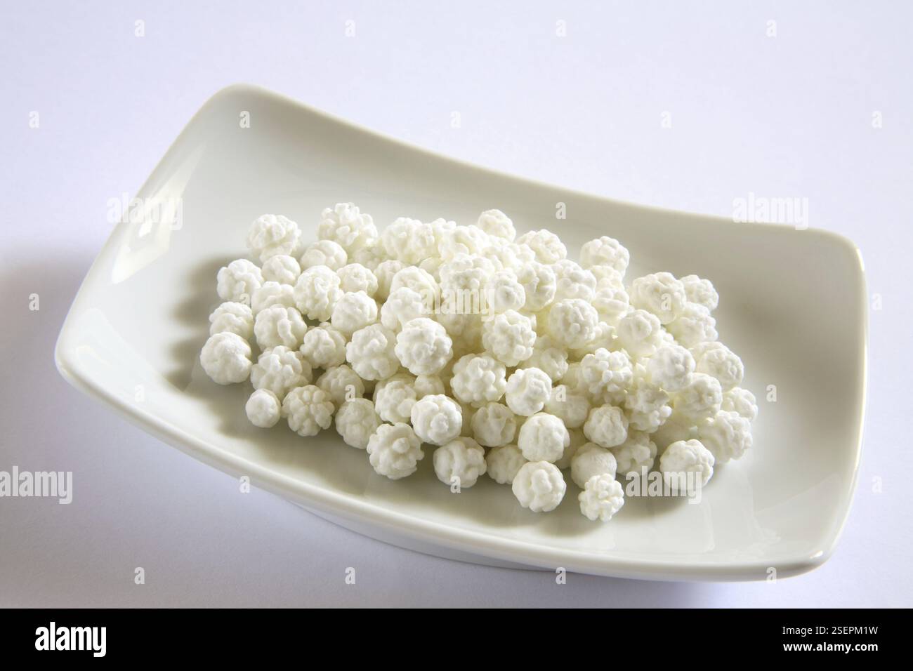 Sweet small sugar ball phutana in plate on white background Stock Photo ...
