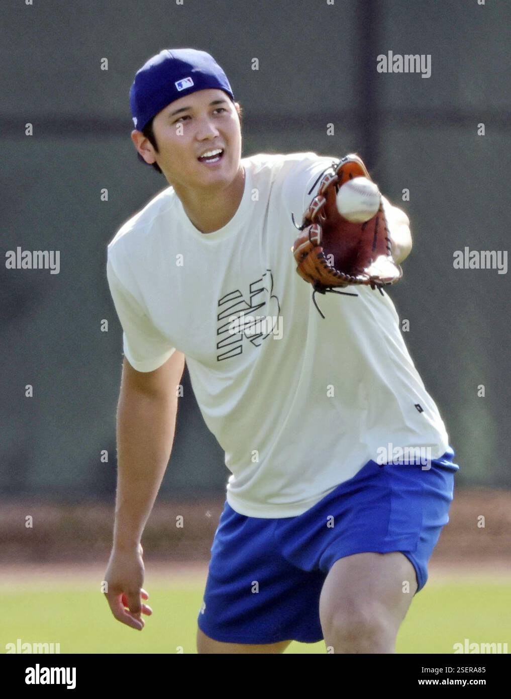 Shohei Ohtani of the Los Angeles Dodgers plays catch during a workout ...