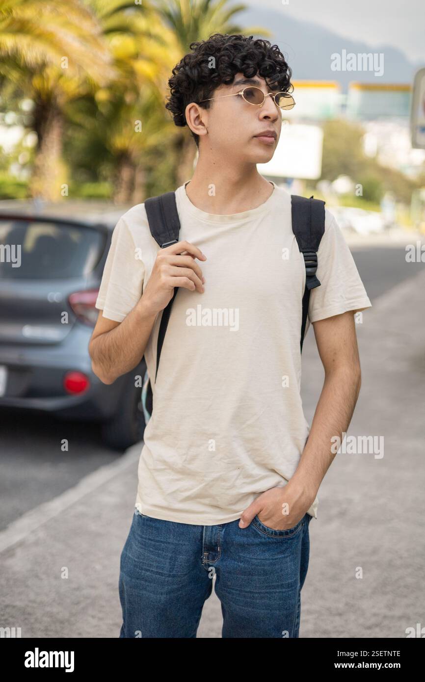 A person standing on the sidewalk, next to the street, observing the ...