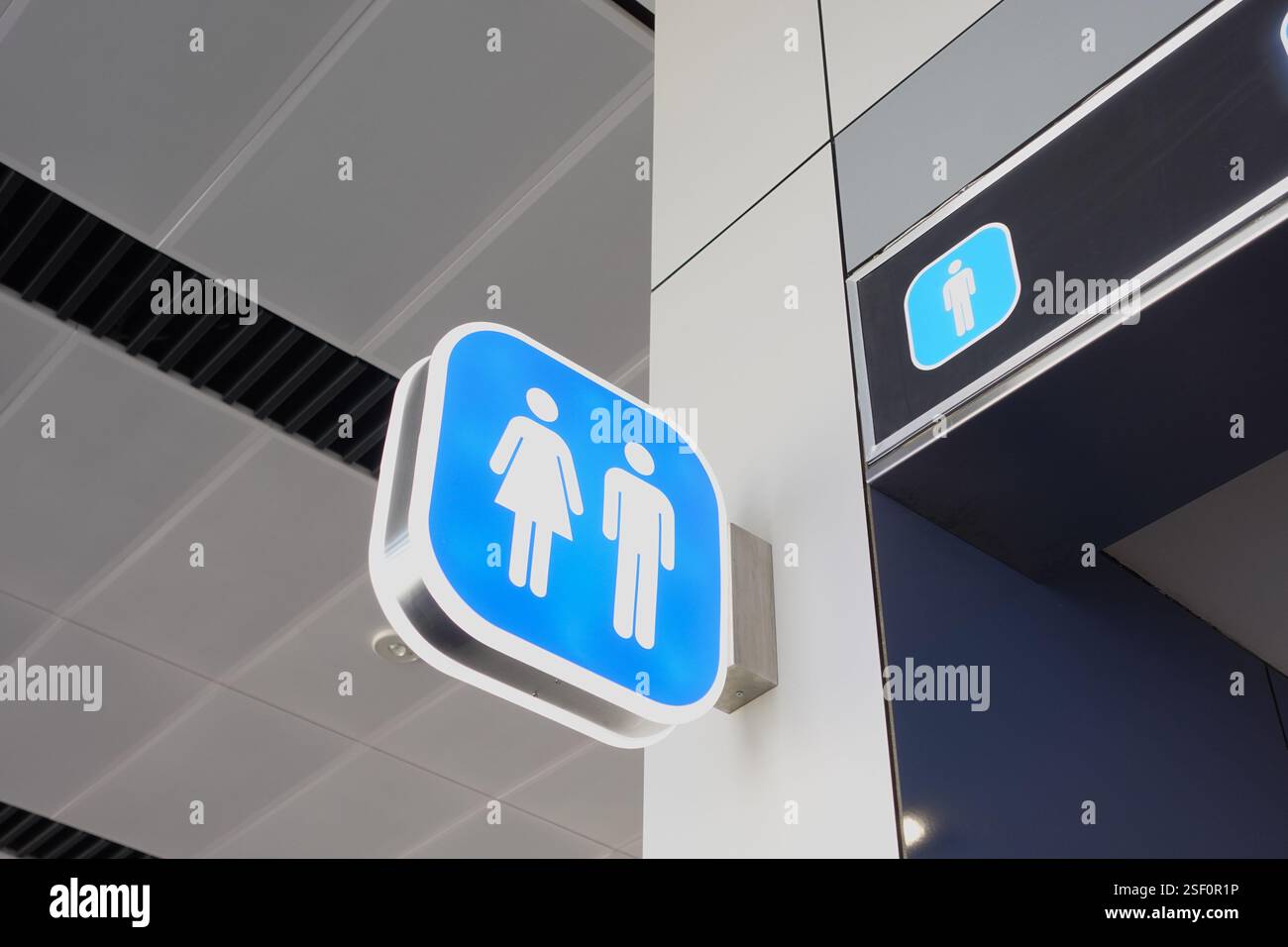 Sign indicating restroom facilities for men and women in an airport ...