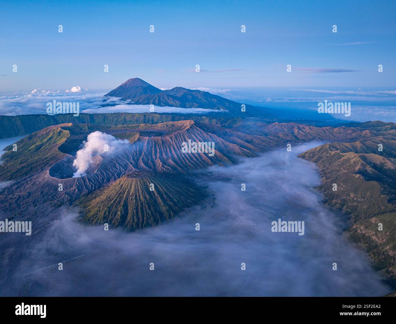 aerial view of breathtaking Mount Bromo surrounded by mist and dramatic ...
