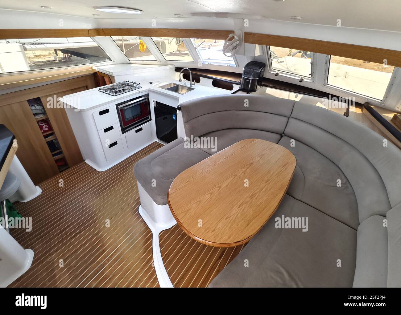 A cozy living room and kitchen featuring a stylish curved couch and a ...