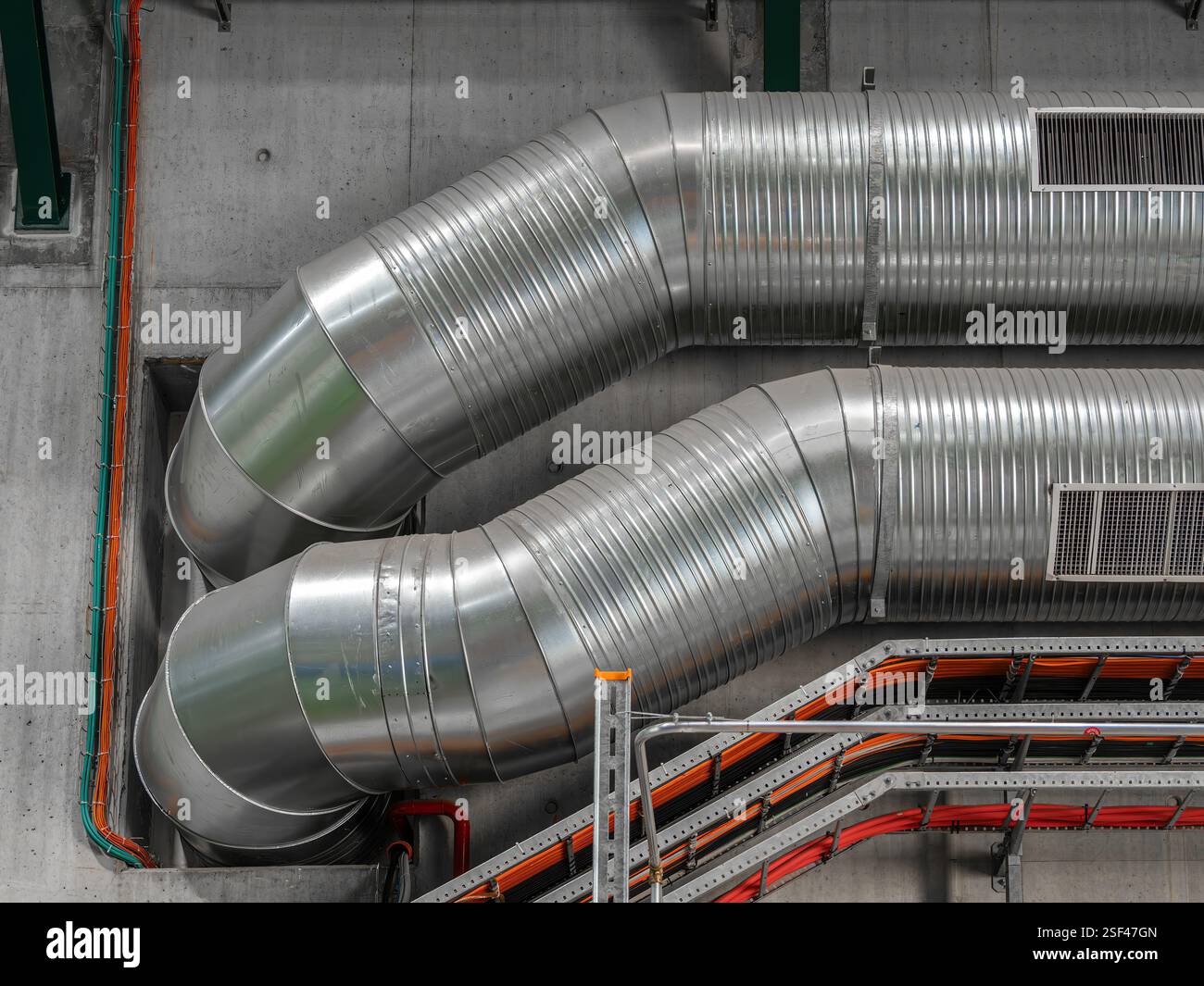 Close-up of large metallic ducts and pipes in an industrial setting ...