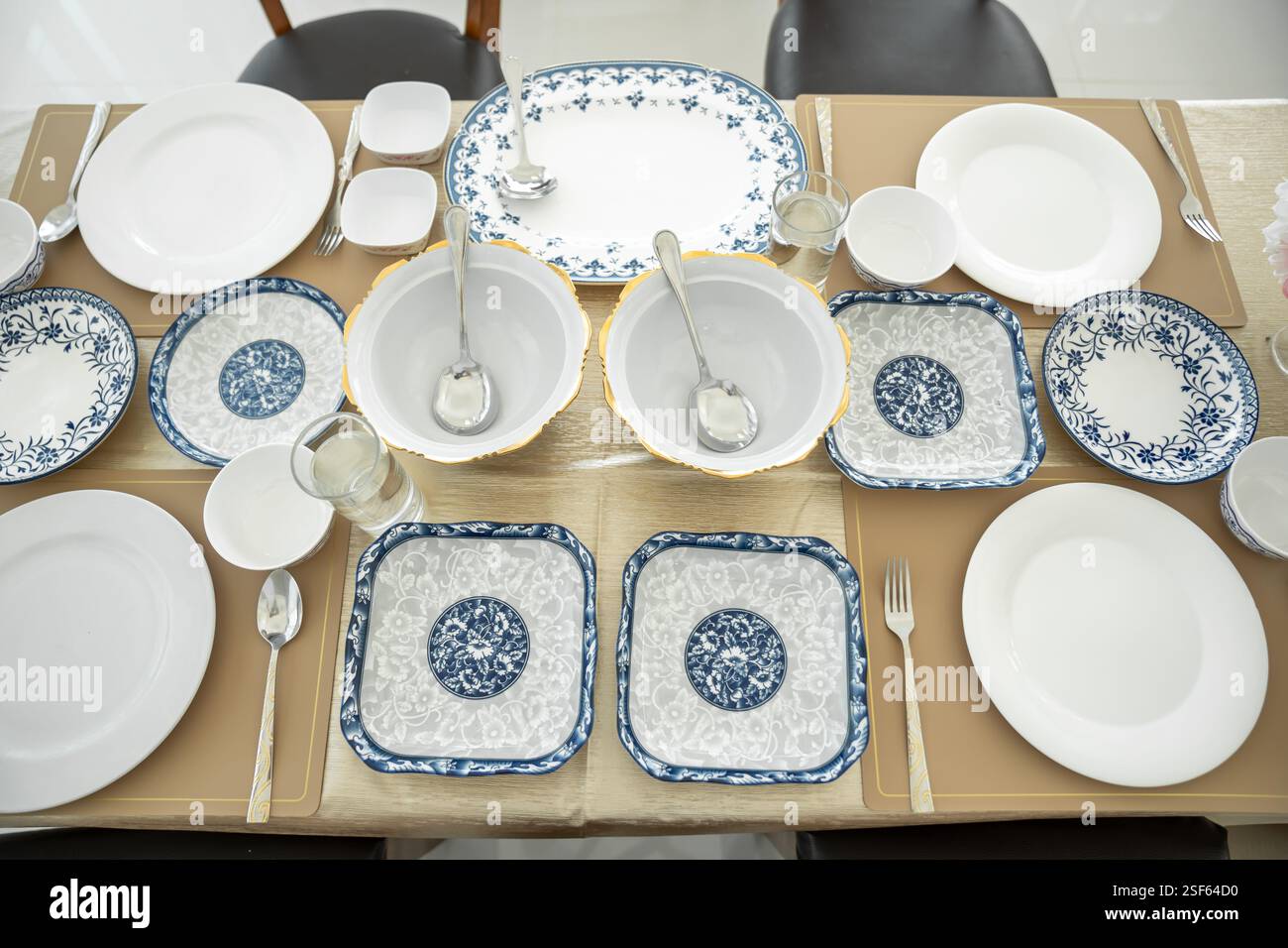 Elegant white ceramic crockery, expertly placed on the table, sets the ...