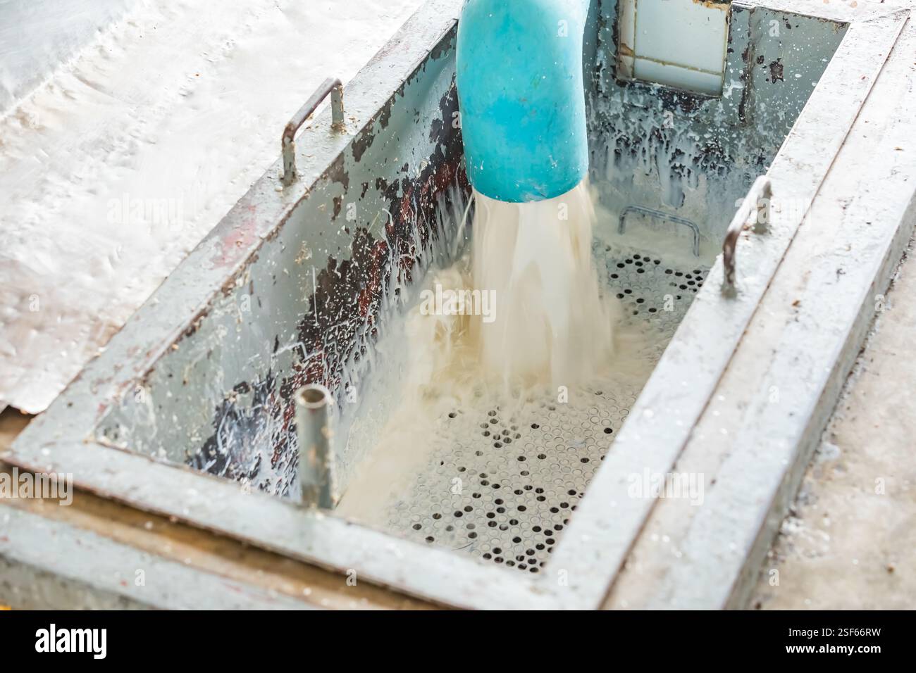 Milky white liquid gush out of the blue plastic industrial water pipe ...