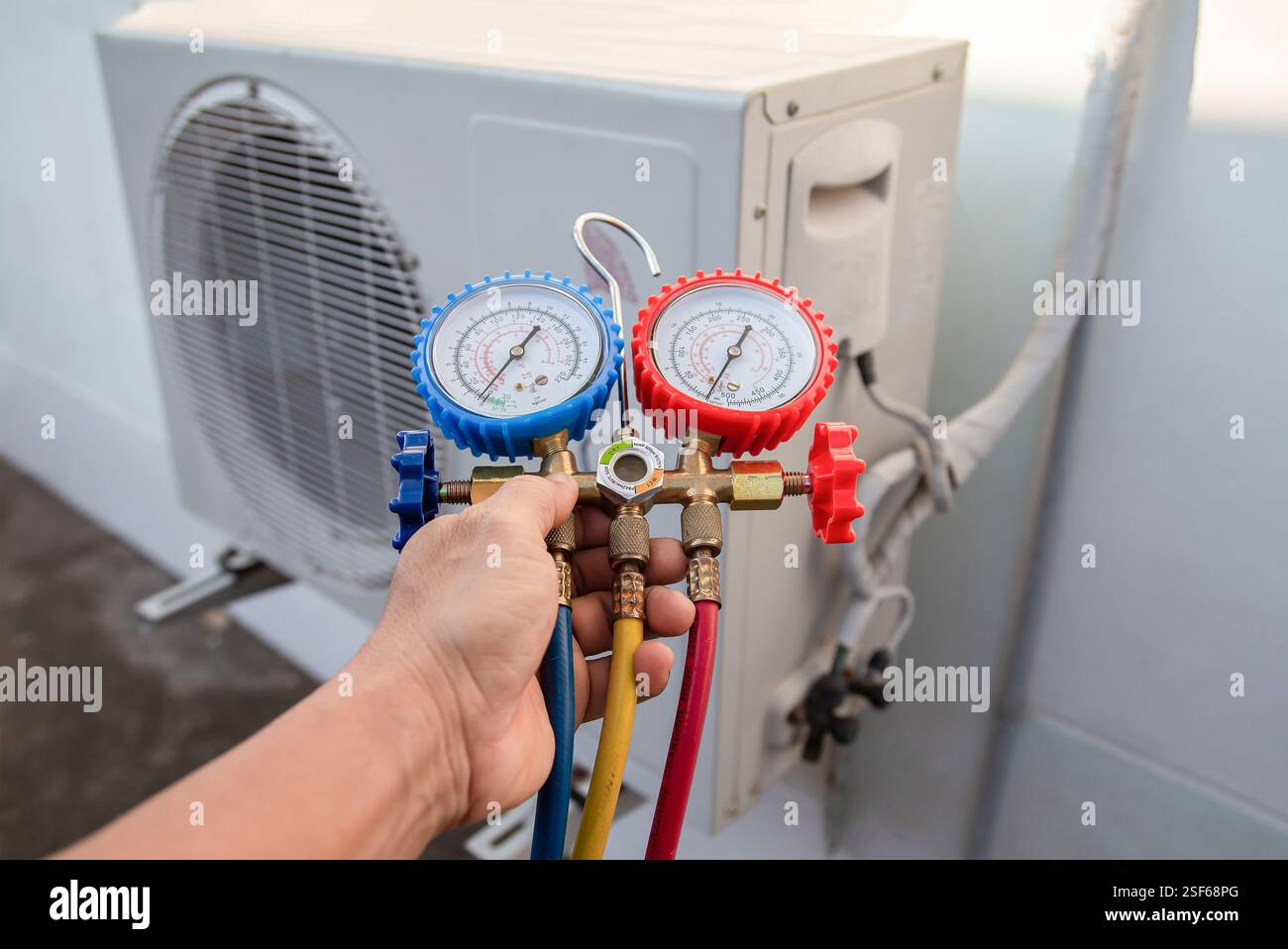 Air conditioning, HVAC service technician using gauges to check ...