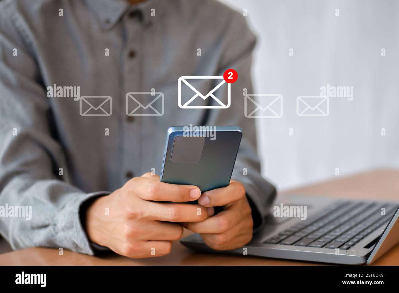Man uses laptop with notification icon of two new email messages ...