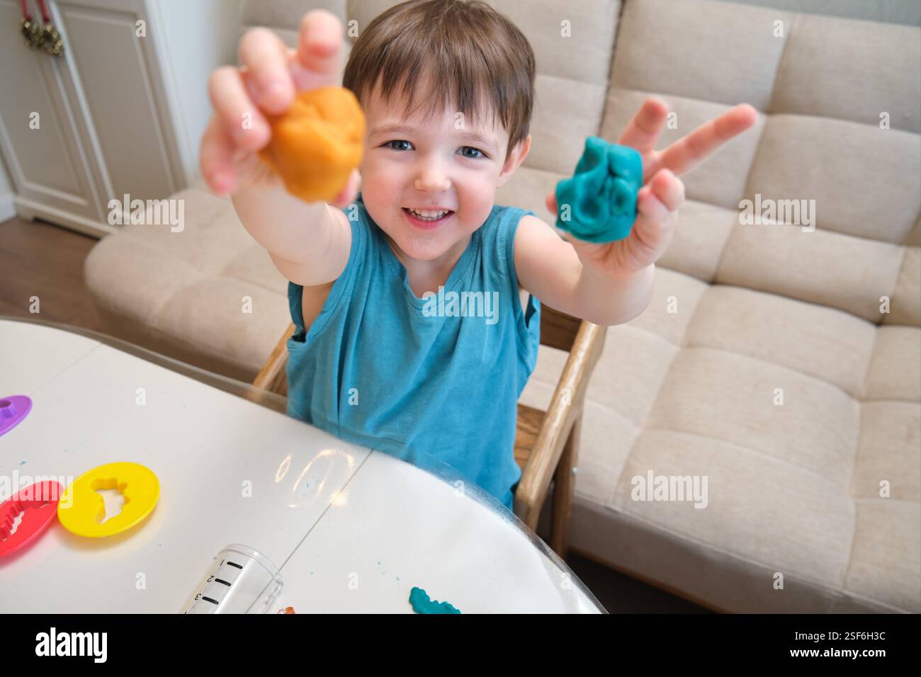 The child uses his hands to create imaginative figures from plasticine ...