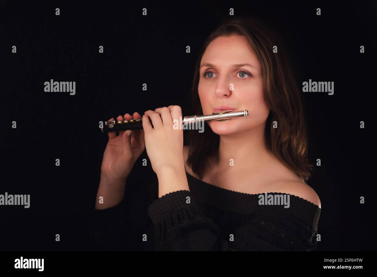Woman holding and playing piccolo flute. Studio portrait of female ...