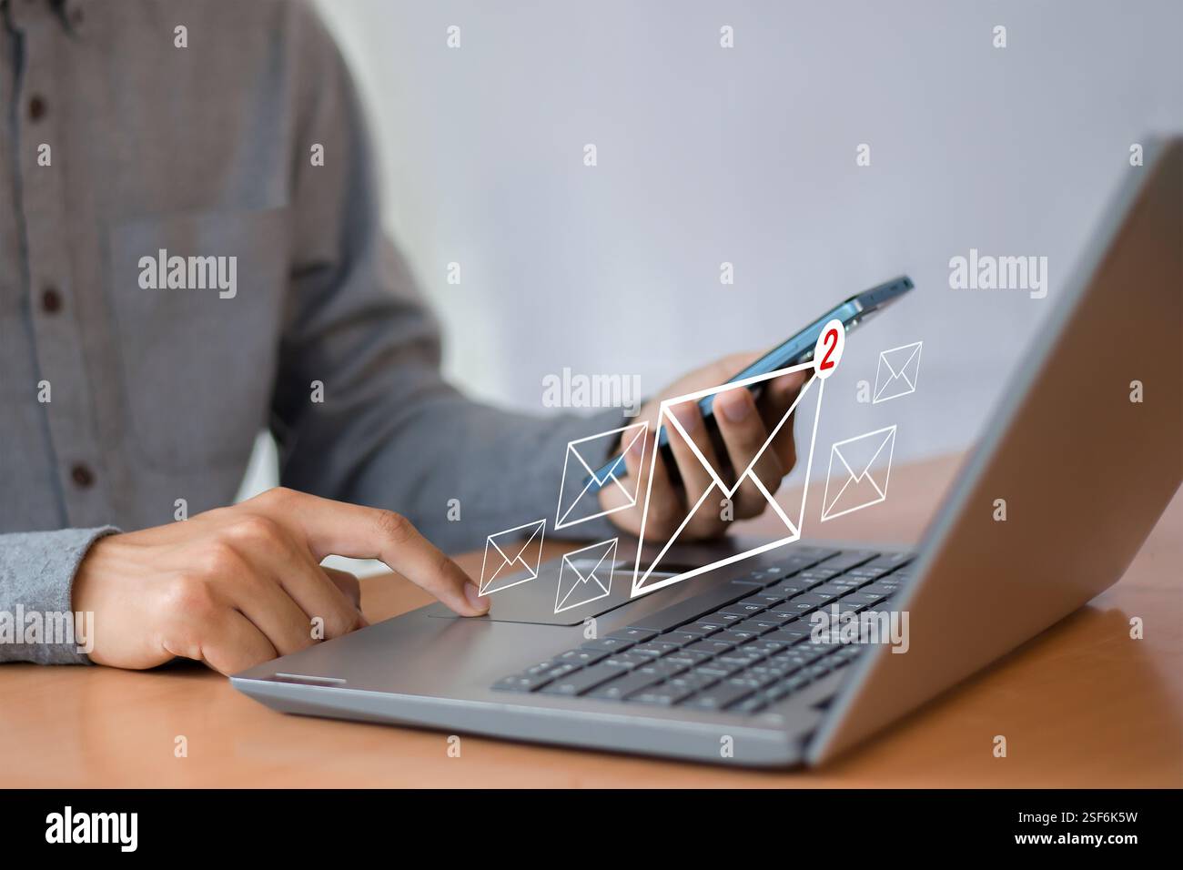 Man uses laptop with notification icon of two new email messages ...