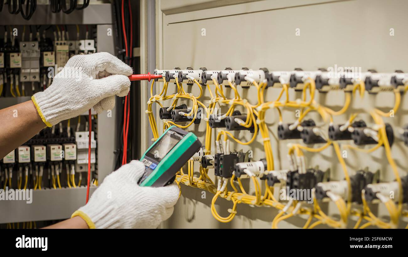 Electrical engineer tests the operation of the electric control cabinet ...
