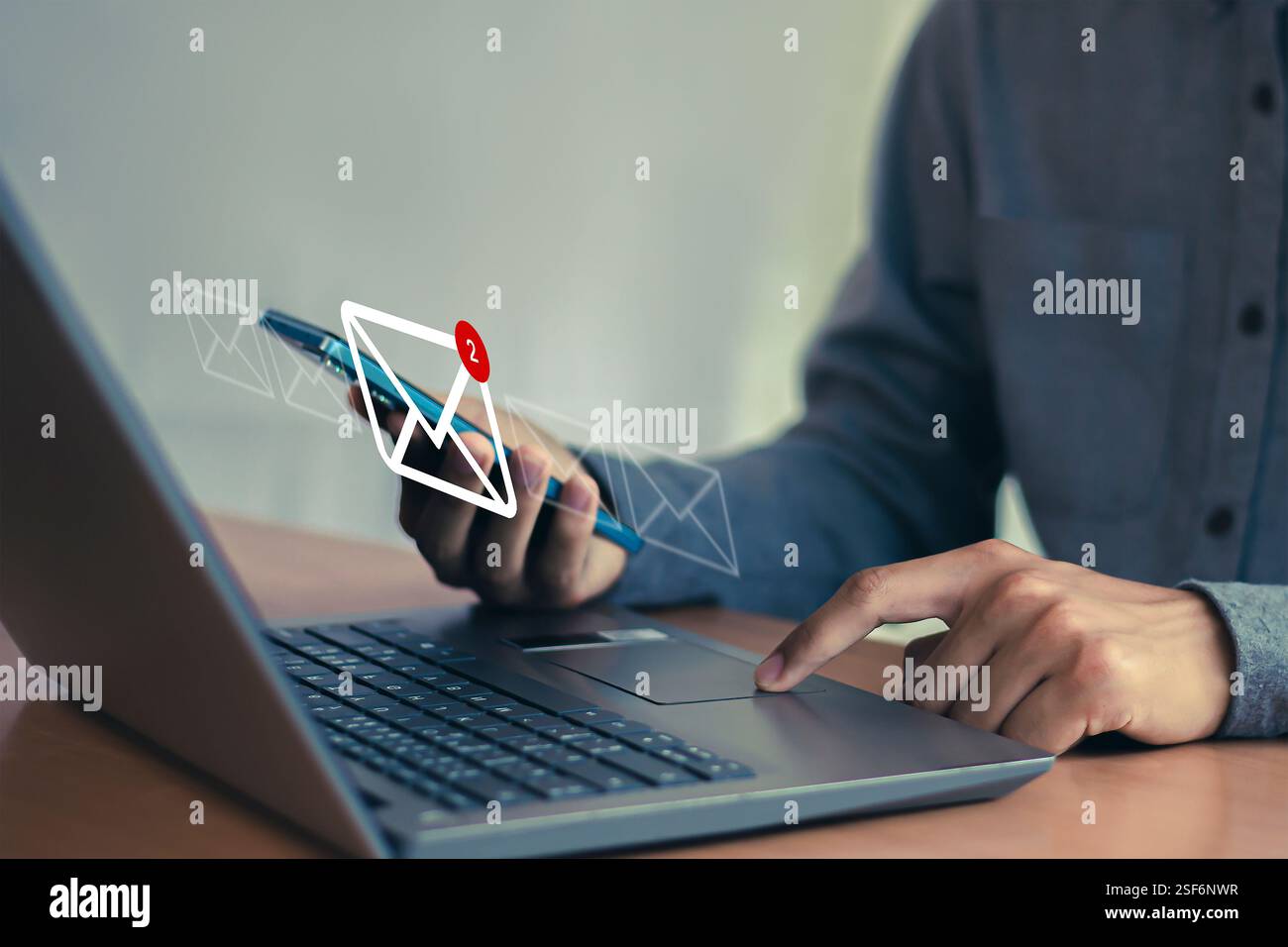 Man uses laptop with notification icon of two new email messages ...