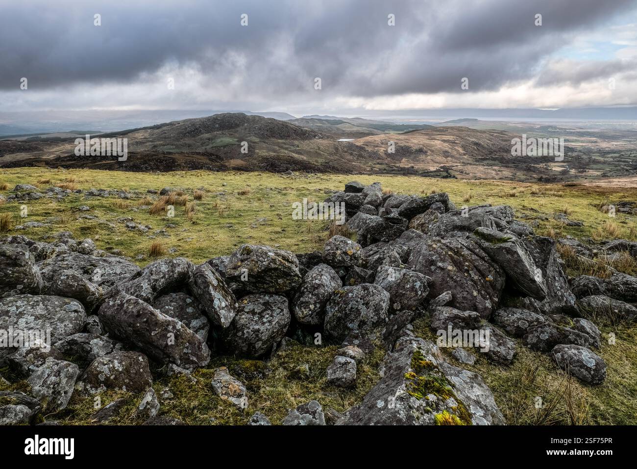 Landscape of rugged rocks and hills under dynamic clouds in a remote ...