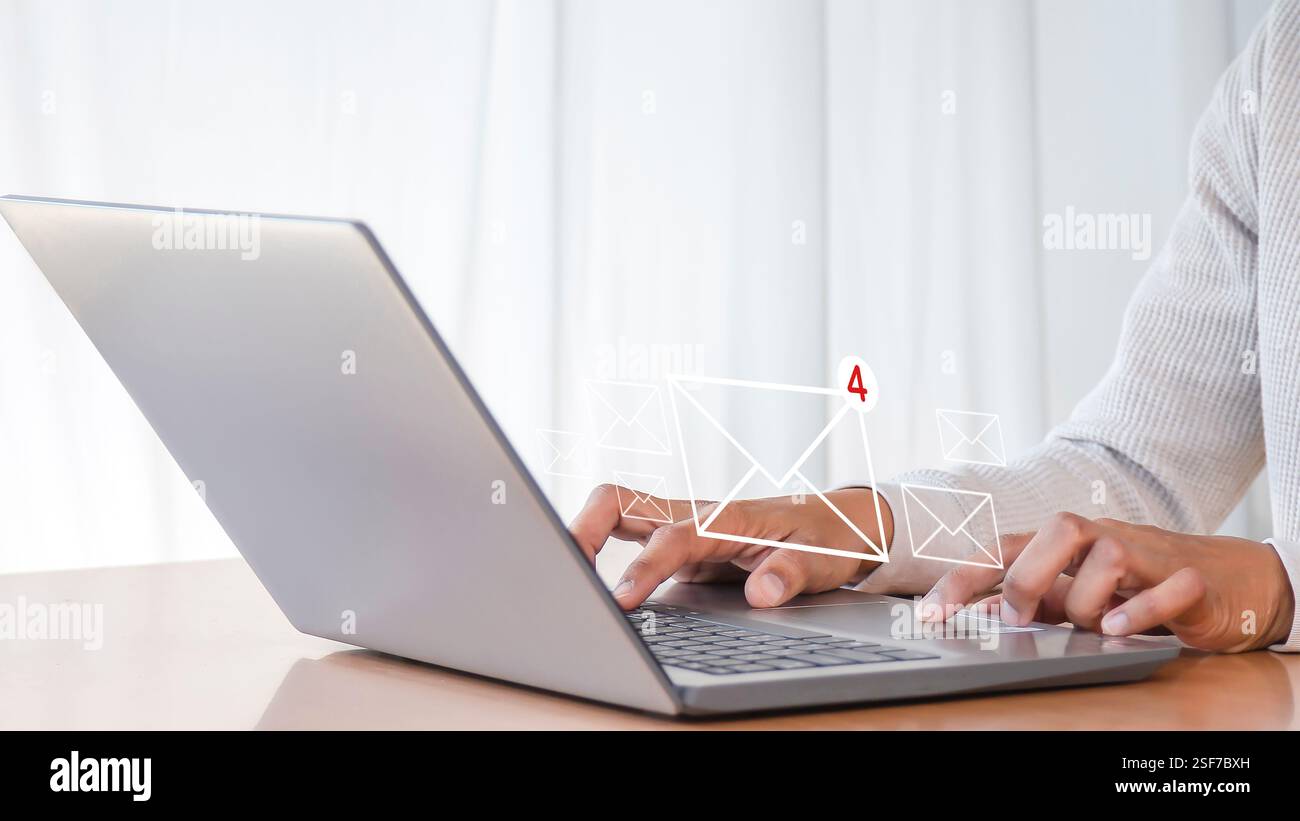 Woman uses laptop with 4 new email message notification icons ...