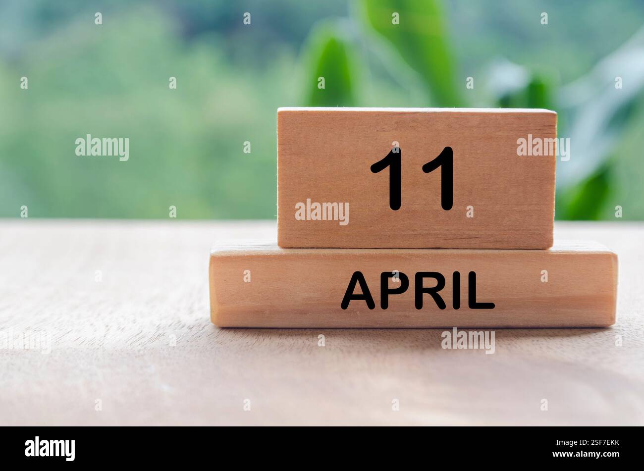 11 April calendar on wooden table with customizable space for text ...