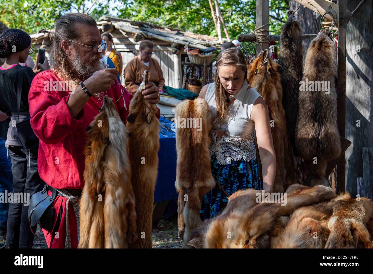 Fur vendor and customer browsing fox furs at Pukkisaari Iron Age Market ...