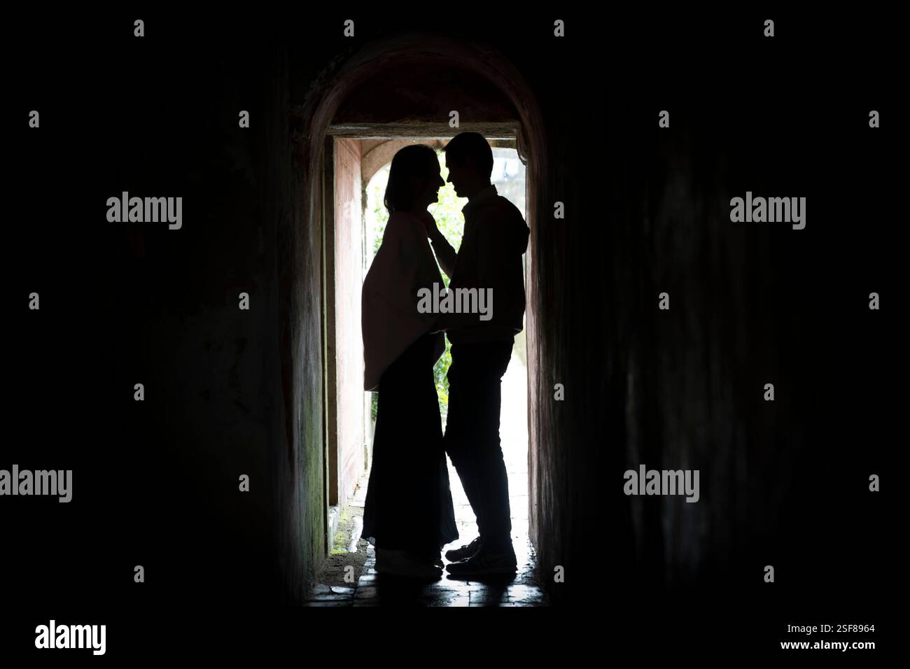 Romantic couple sharing intimate moment in dark archway Stock Photo - Alamy