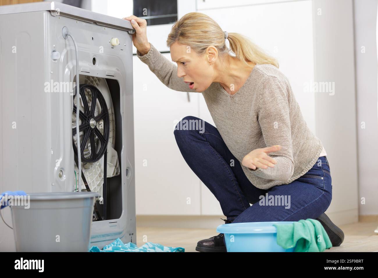worried female experiencing problems with washing machine Stock Photo ...