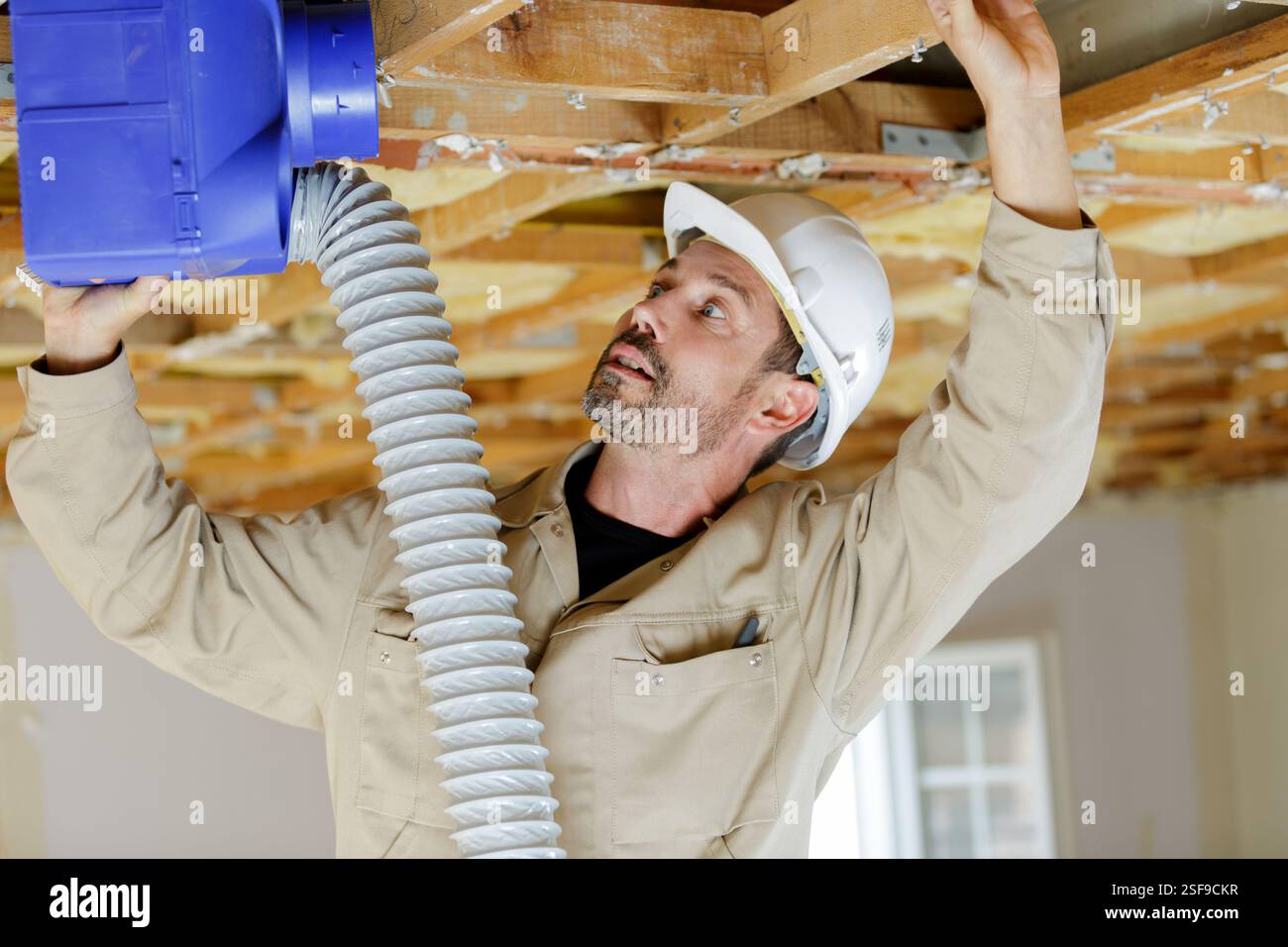 male contractor installing new ventilation system Stock Photo - Alamy