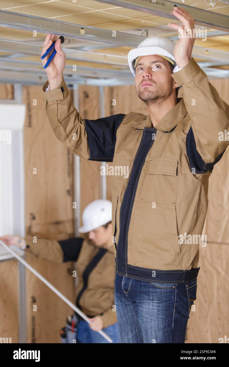 builder using tool to fix ceiling Stock Photo - Alamy