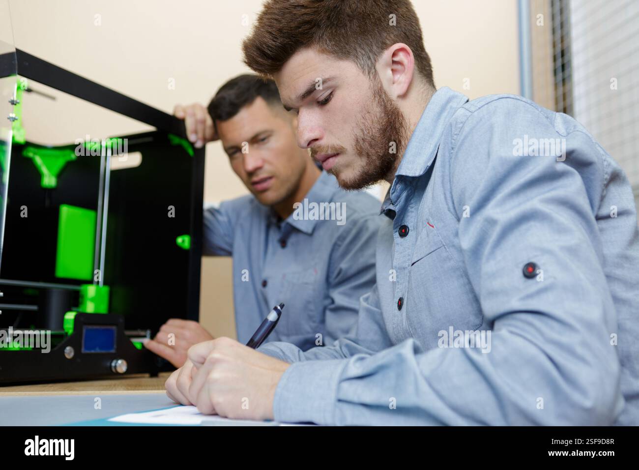 male worker making notes by 3d printer Stock Photo - Alamy