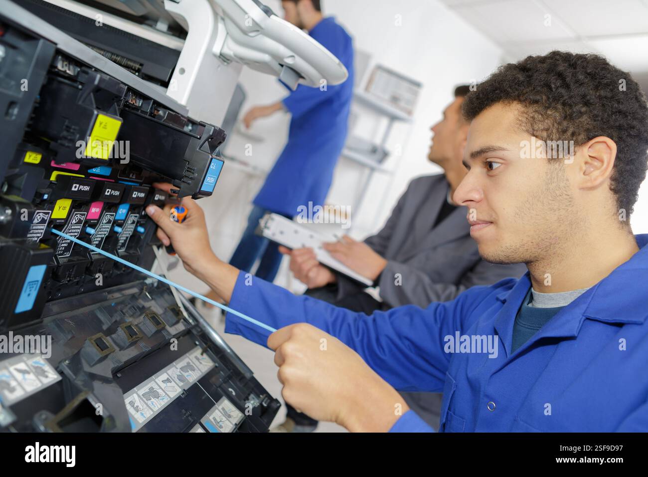 technician using a tablet to fix a printer Stock Photo - Alamy