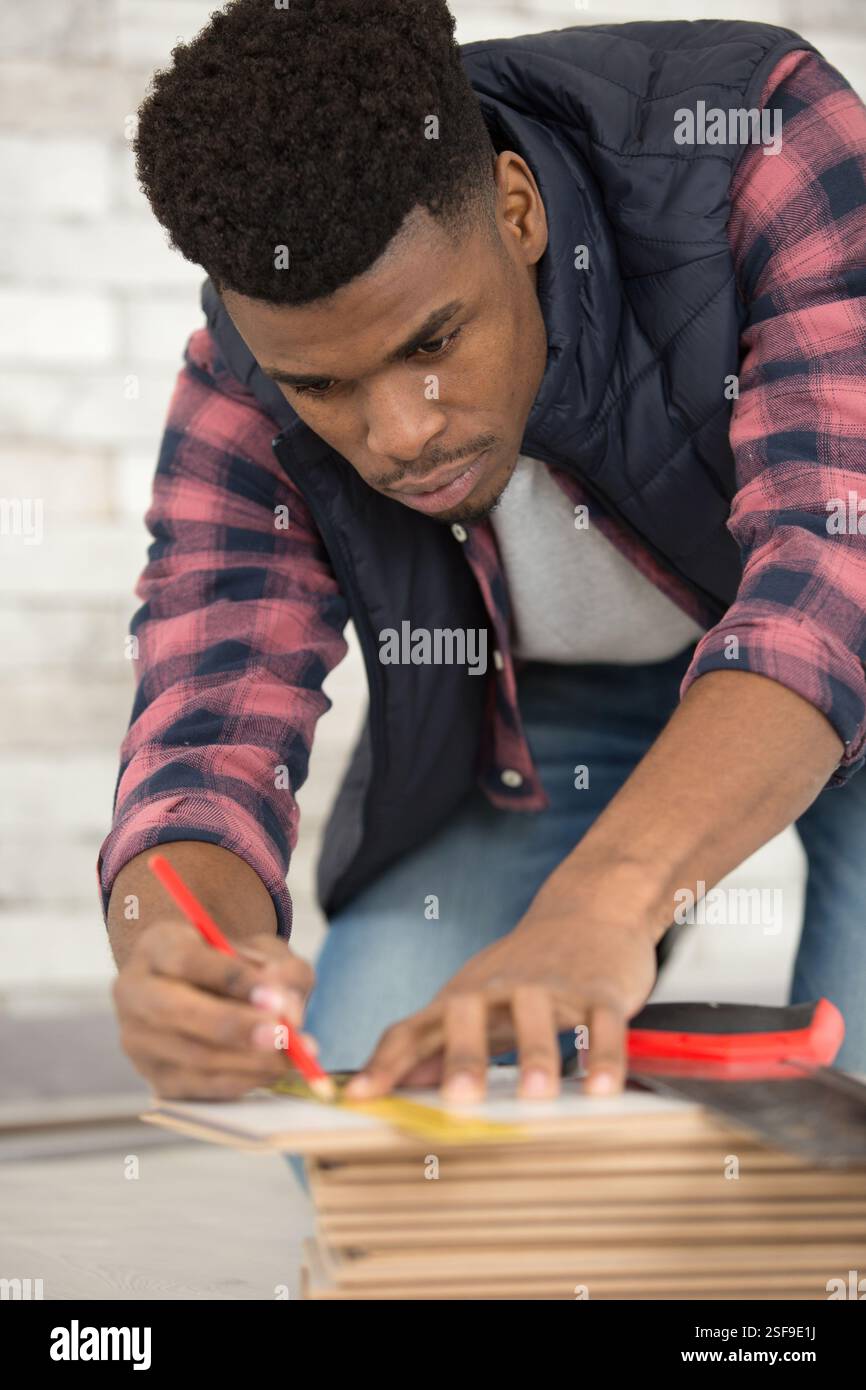 workman measuring width of floor board Stock Photo - Alamy
