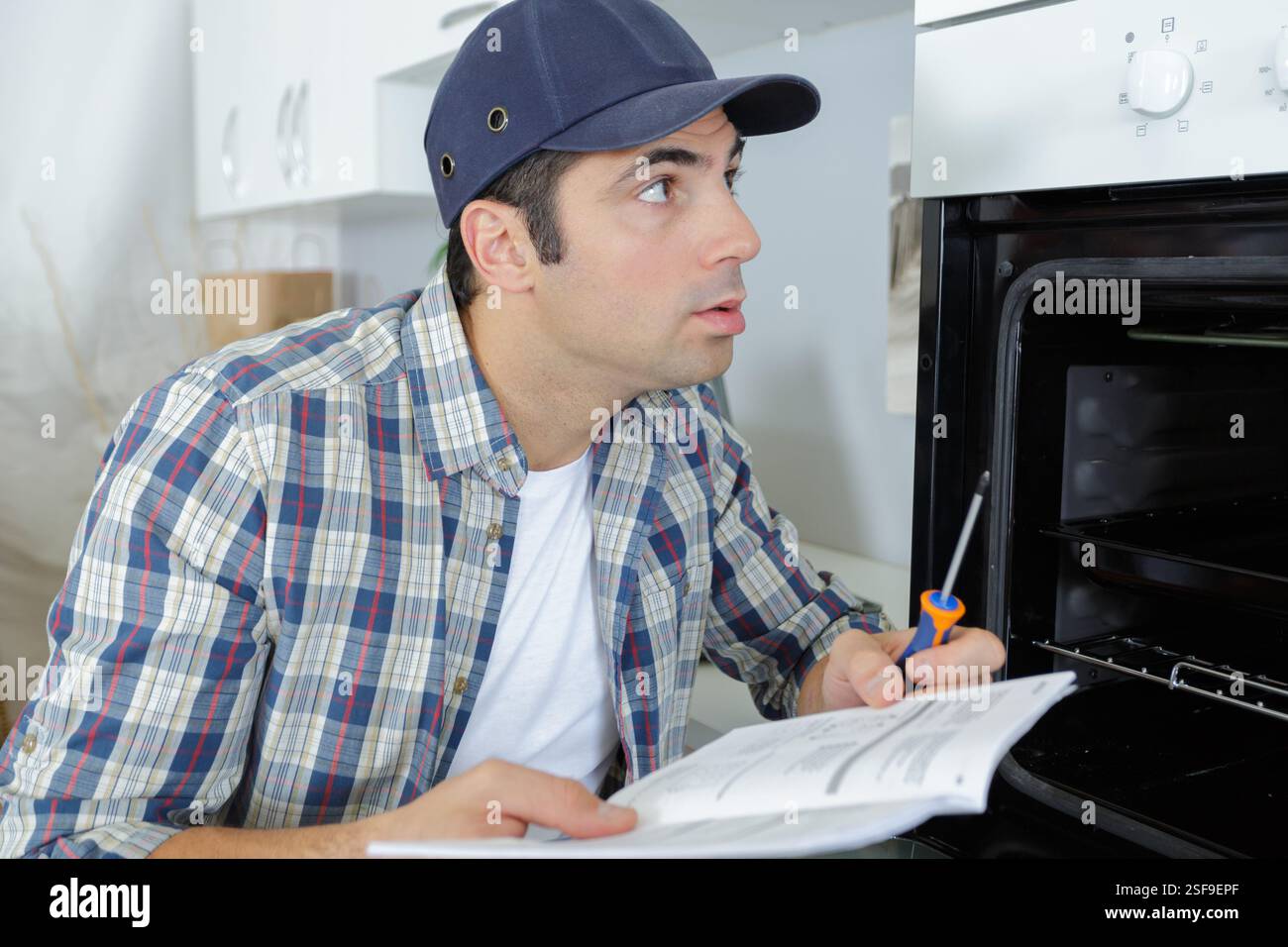 Male worker installing oven hi-res stock photography and images - Alamy