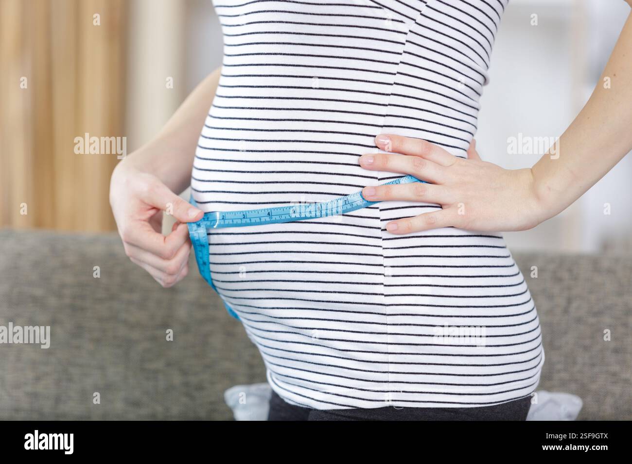 a pregnant woman measuring belly Stock Photo - Alamy
