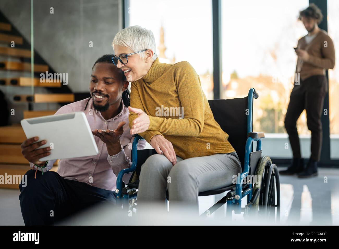 Disabled woman in wheelchair looking at computer, discussing startup ...