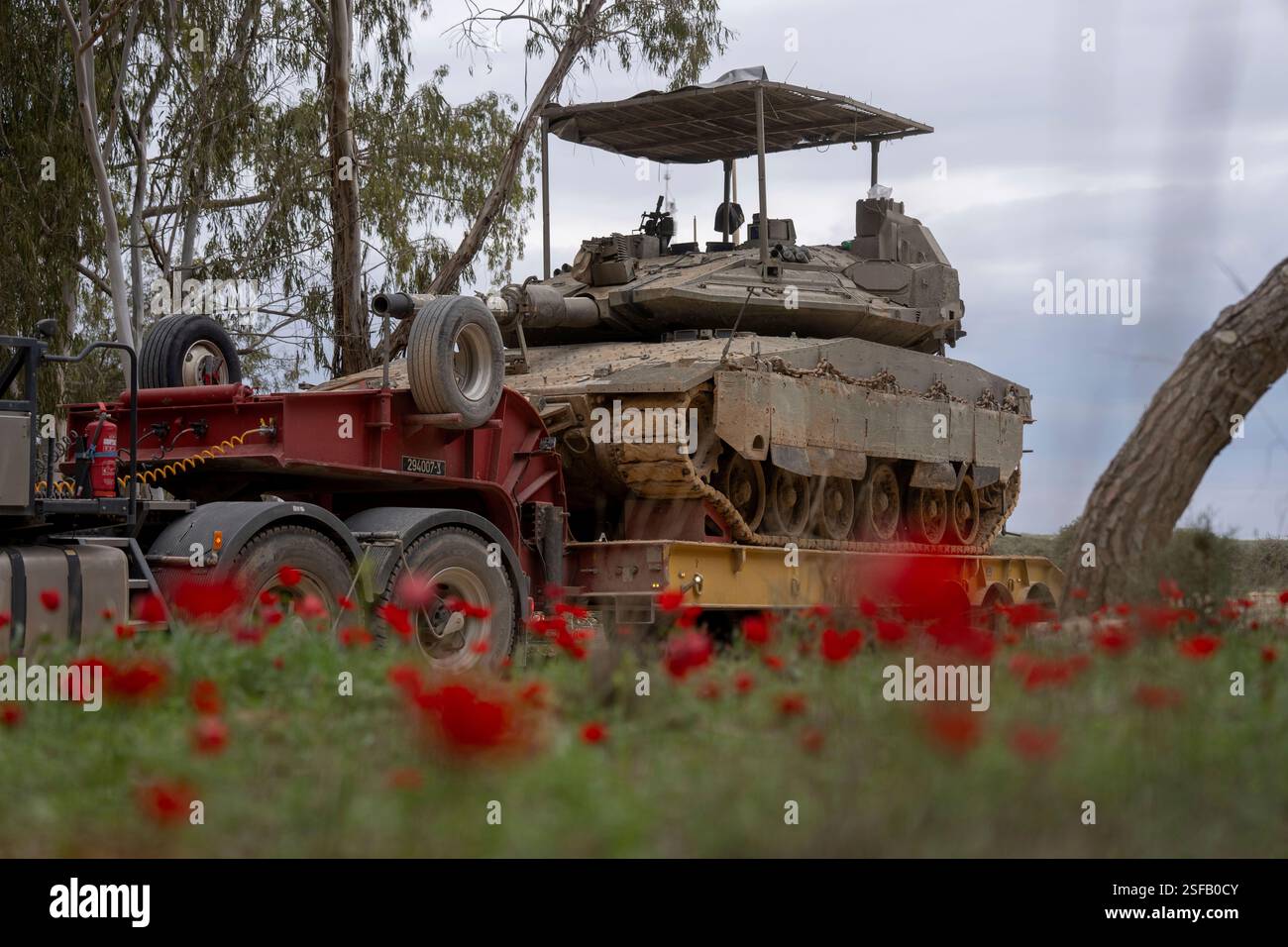 An Israeli tank is loaded onto a transport truck near the border with ...