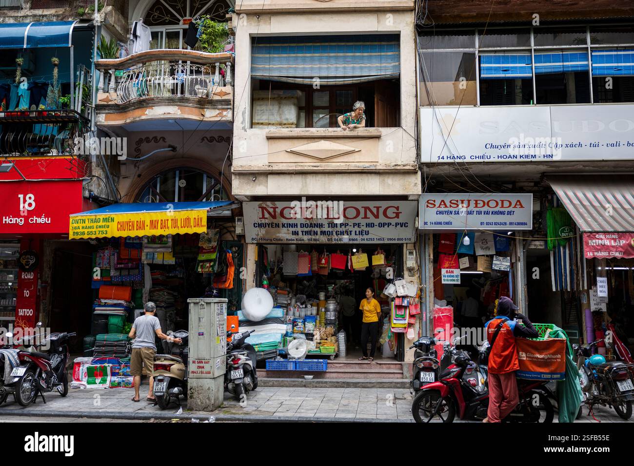 Hanoi, Vietnam - 31 July 2024 : Woman by the balcony on a street full ...