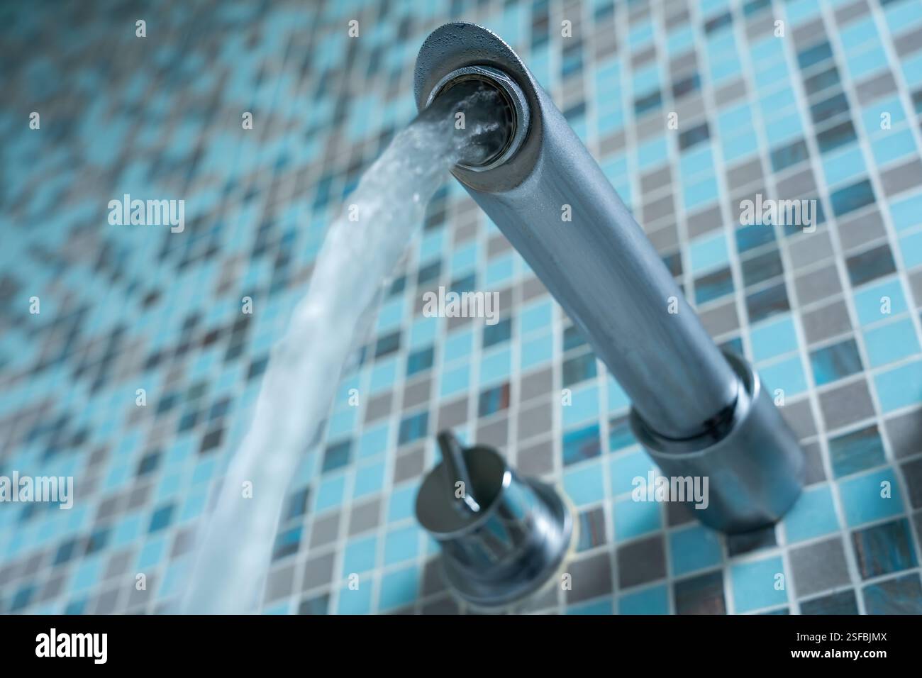 Bathroom mixer tap running water seen from below in an England bathroom ...