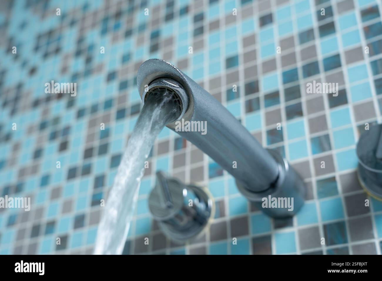 Bathroom mixer tap running water seen from below in an England bathroom ...