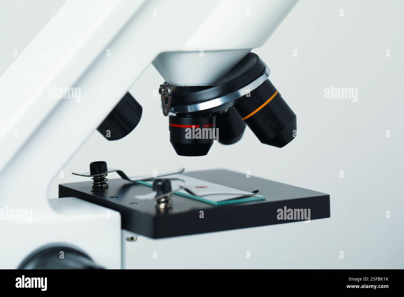 Science. Microscope with glass slide on light grey background, closeup ...
