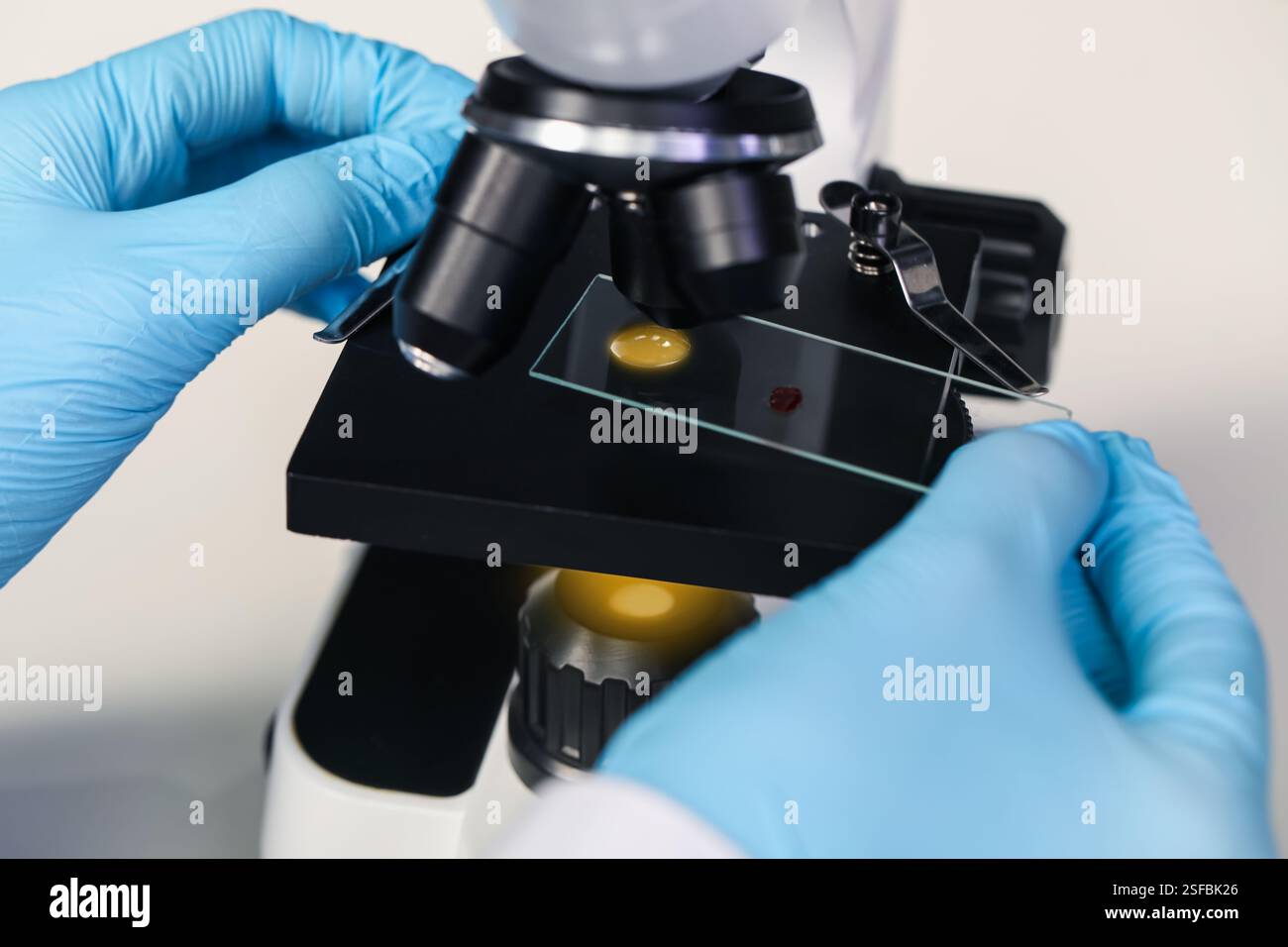 Scientist examining sample on slide under microscope, closeup Stock ...