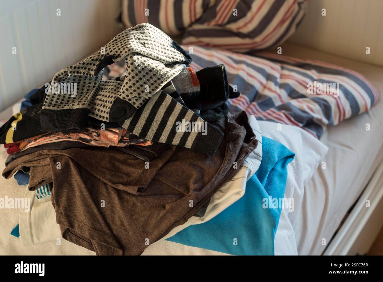collection of washed clothes dropped on the bed Stock Photo - Alamy