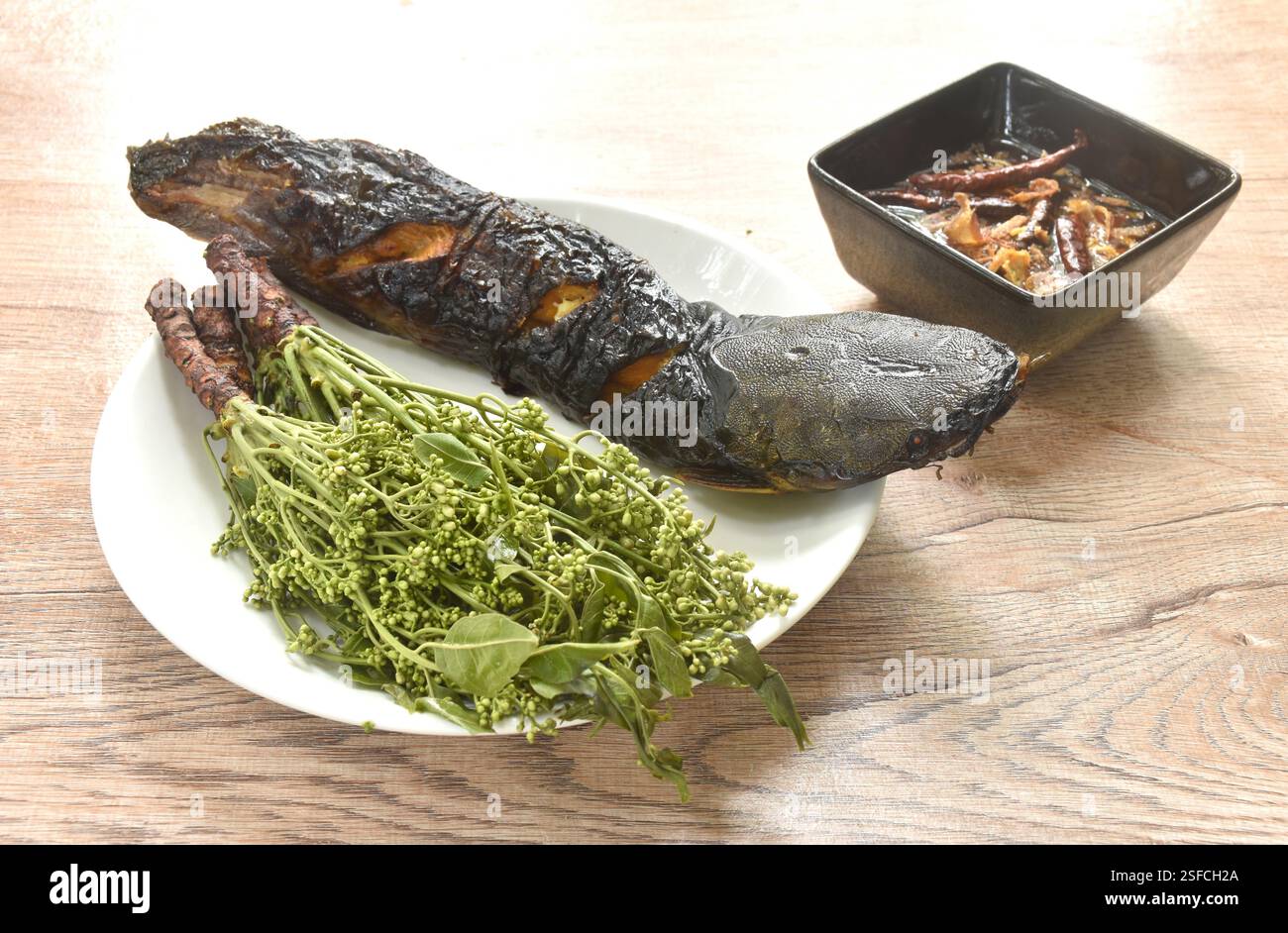 grilled catfish and Siamese neem tree Indian vegetable on plate dipping ...