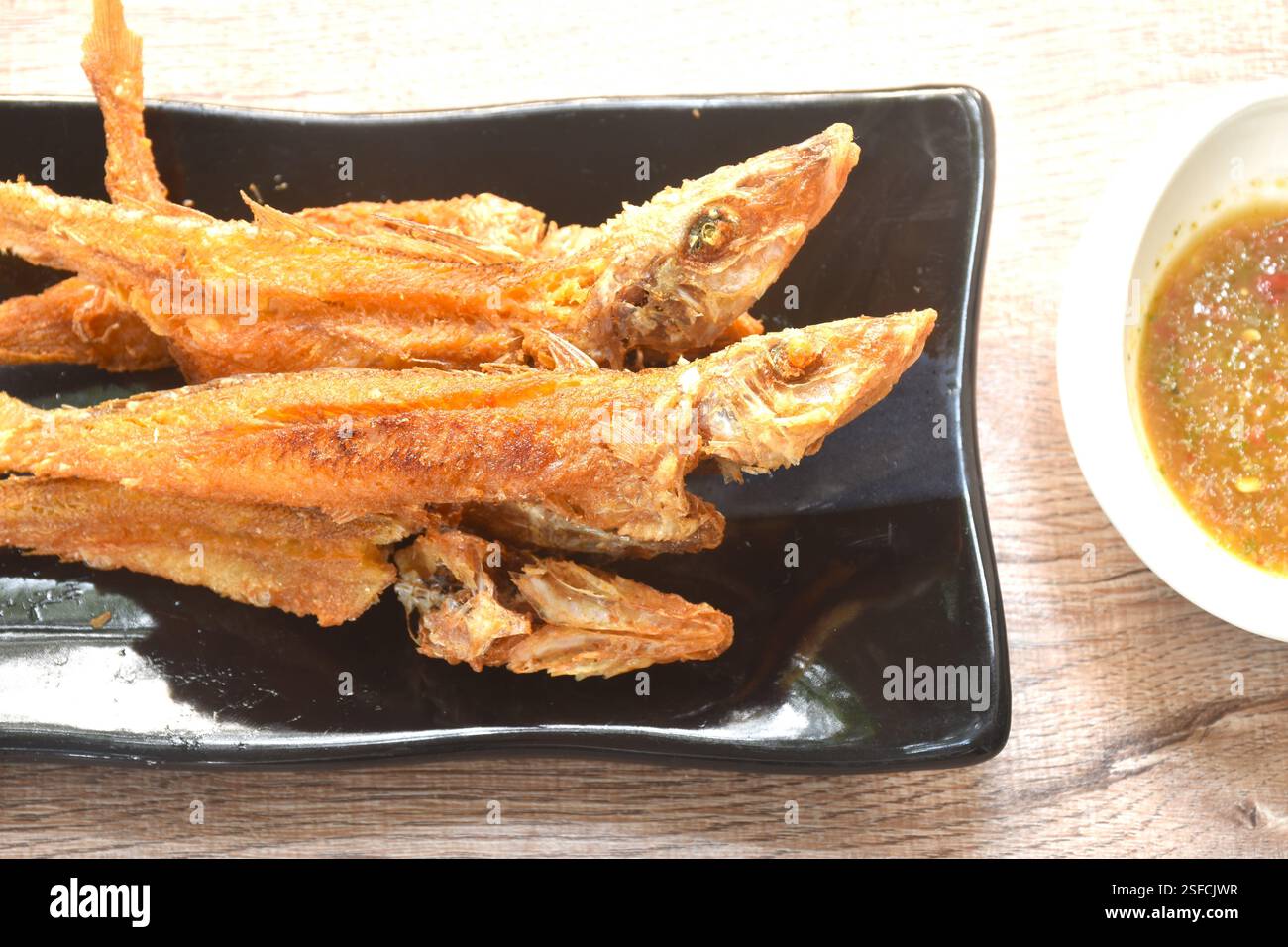 crispy fried sand whiting fish arranging on plate dipping spicy chili ...