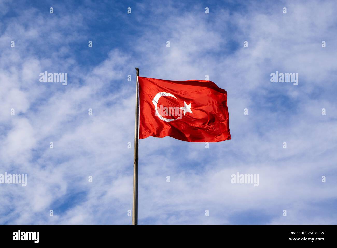 Turkish flag waving on flagpole against blue sky background Stock Photo ...